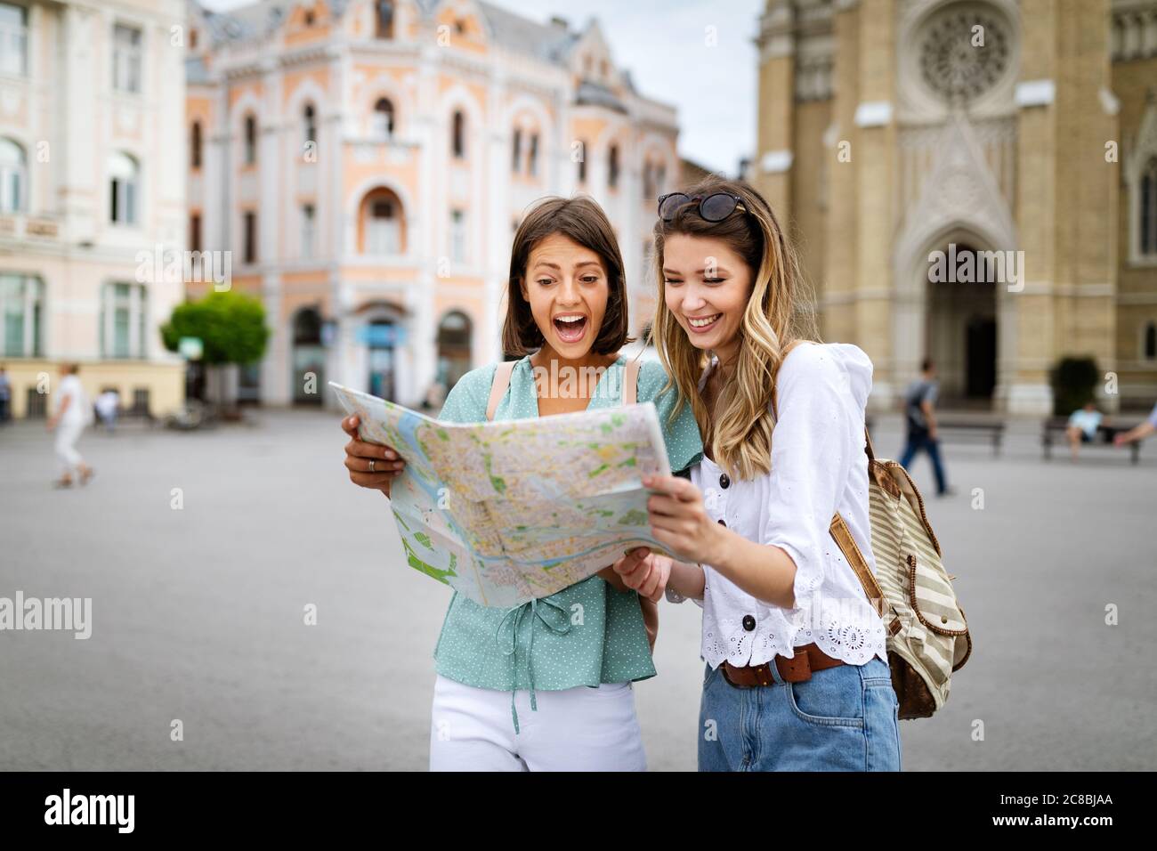 Holidays, travel, friends and tourism concept. Beautiful girls looking ...