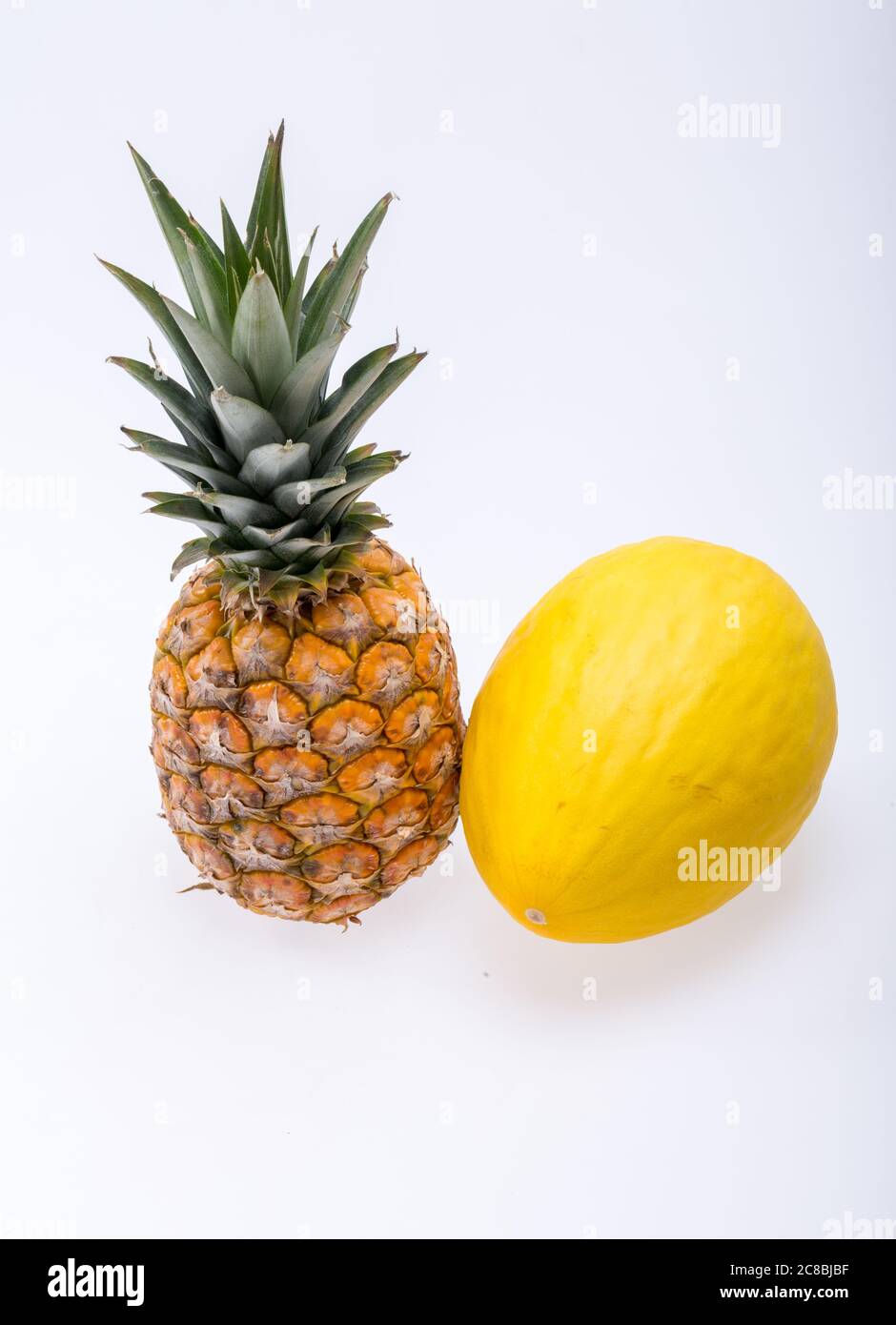 Ripe, fresh pineapple and yellow melon isolated on white background ...