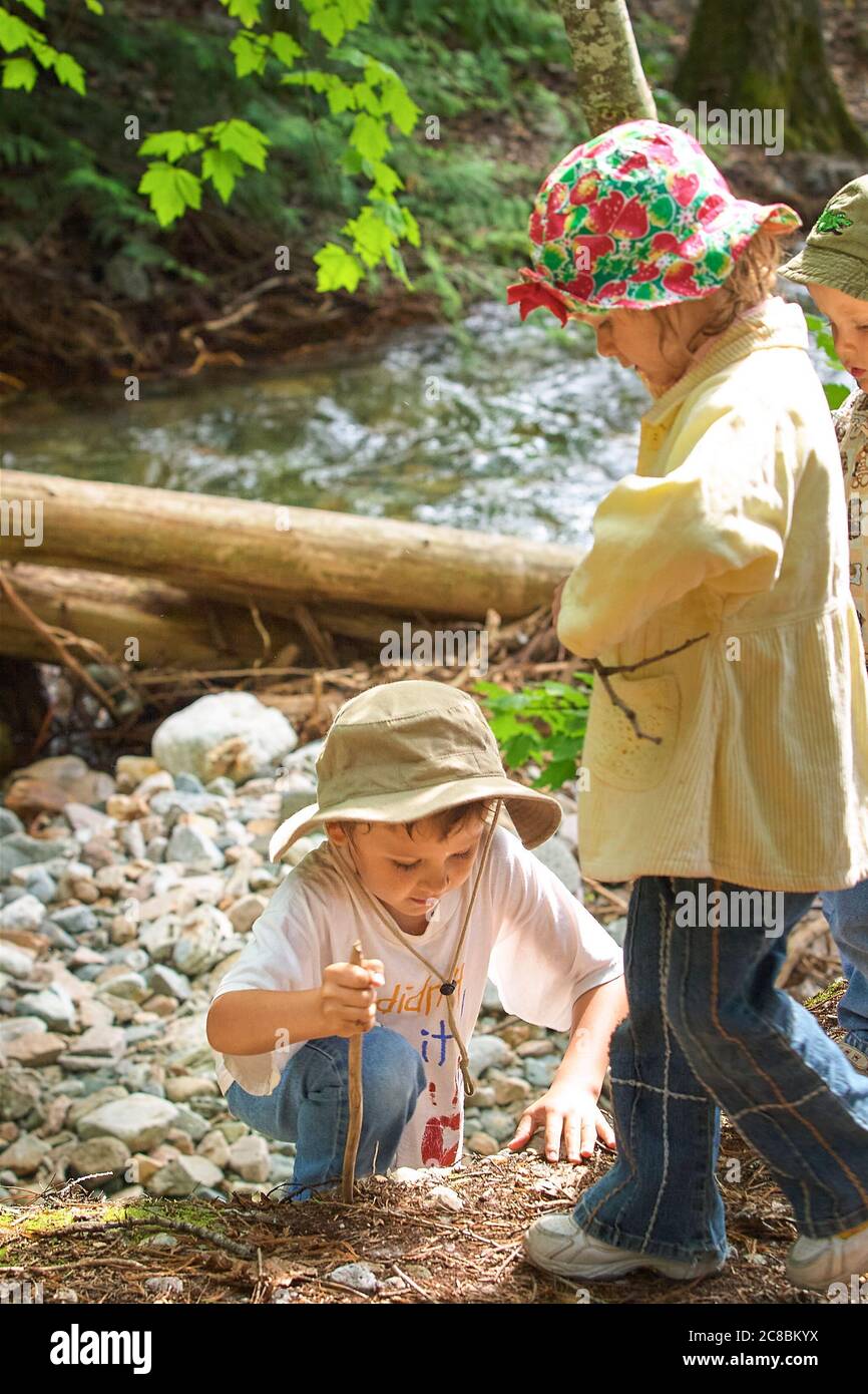 Two children play near a stream Stock Photo - Alamy