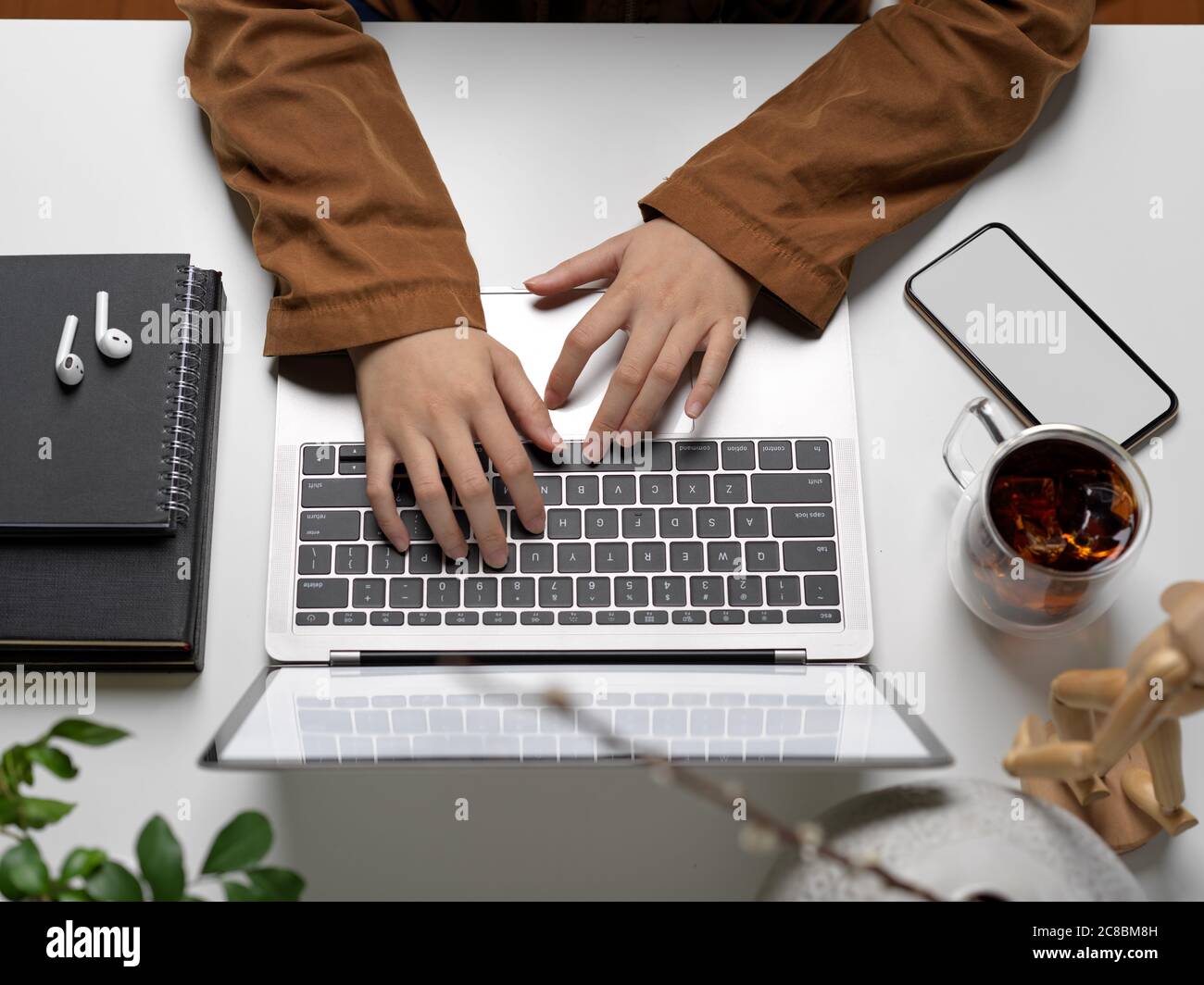 Overhead shot of female typing on laptop with clipping path on office ...