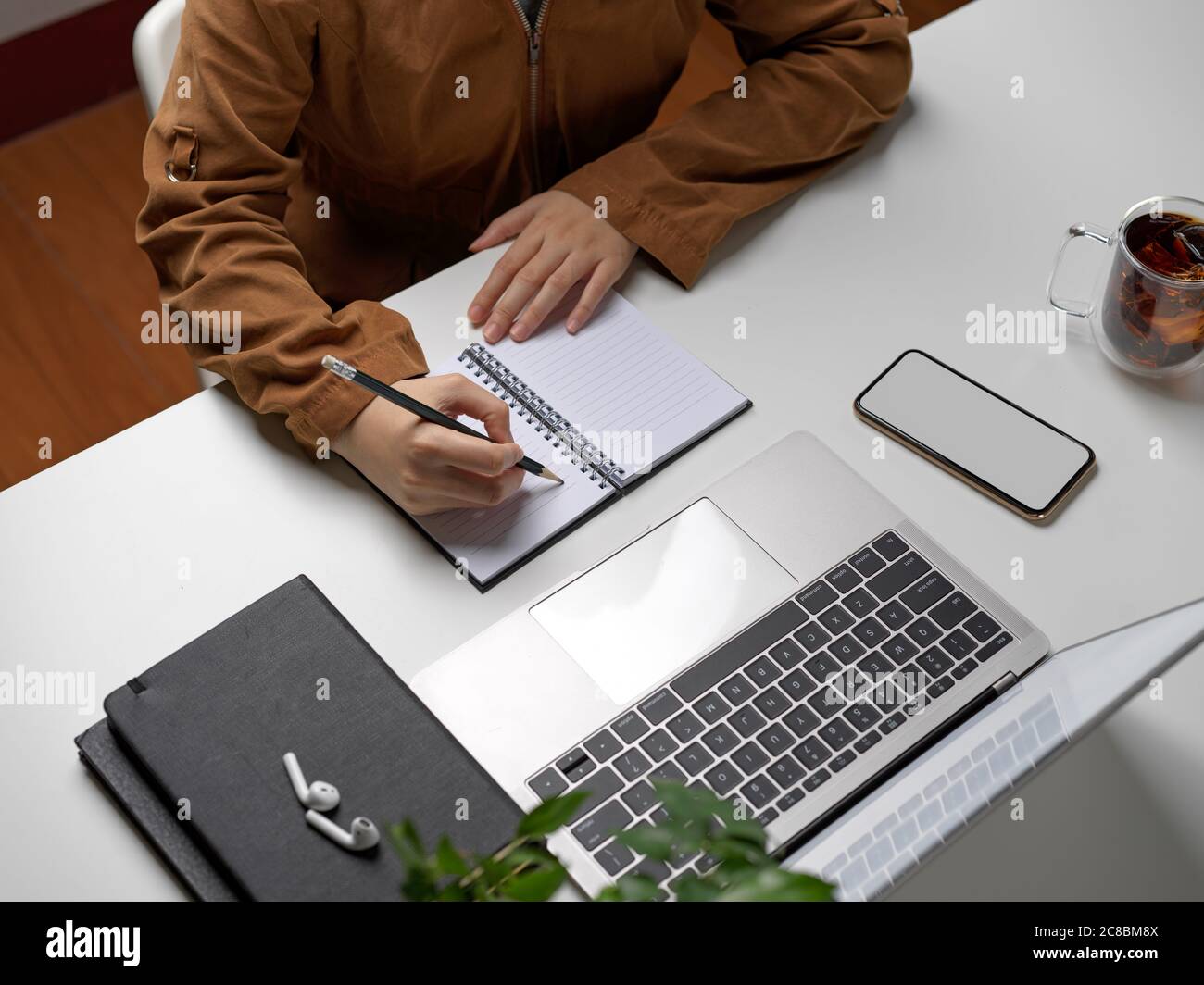Cropped shot of female office worker taking note on schedule book while ...