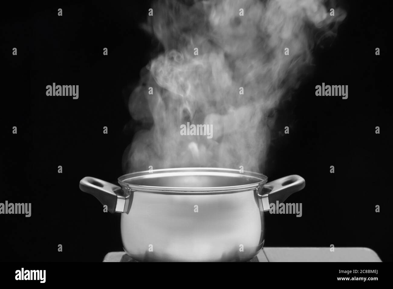 steam over cooking pot in kitchen on dark background Stock Photo - Alamy