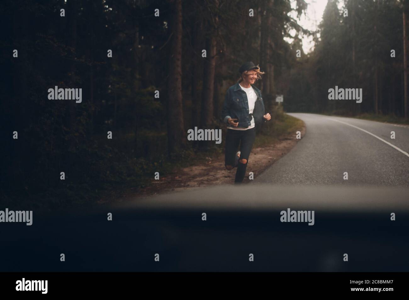 Woman running on the road at forest after leaving car Stock Photo - Alamy