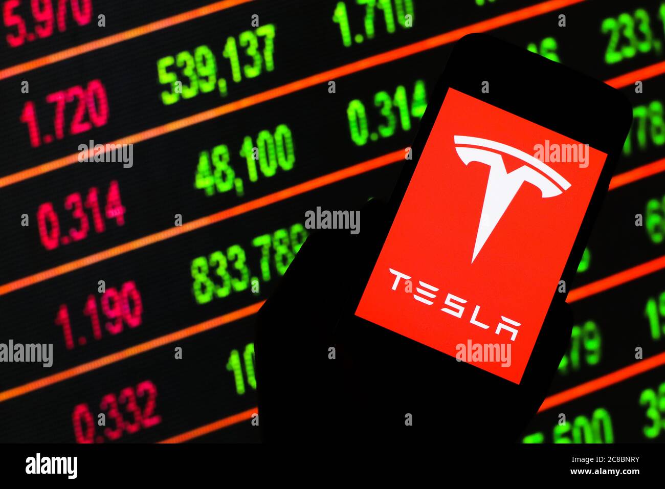 In this photo illustration a Tesla logo seen displayed on a smartphone ...