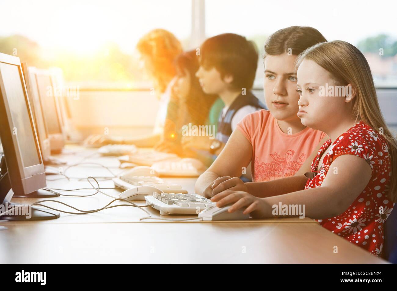 Girl with Down syndrome using computer at school Stock Photo - Alamy