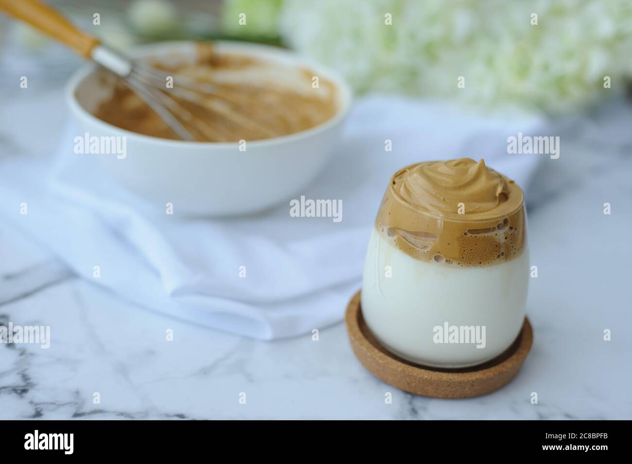 Iced Dalgona Coffee, a trendy fluffy creamy whipped coffee with bowl of ...