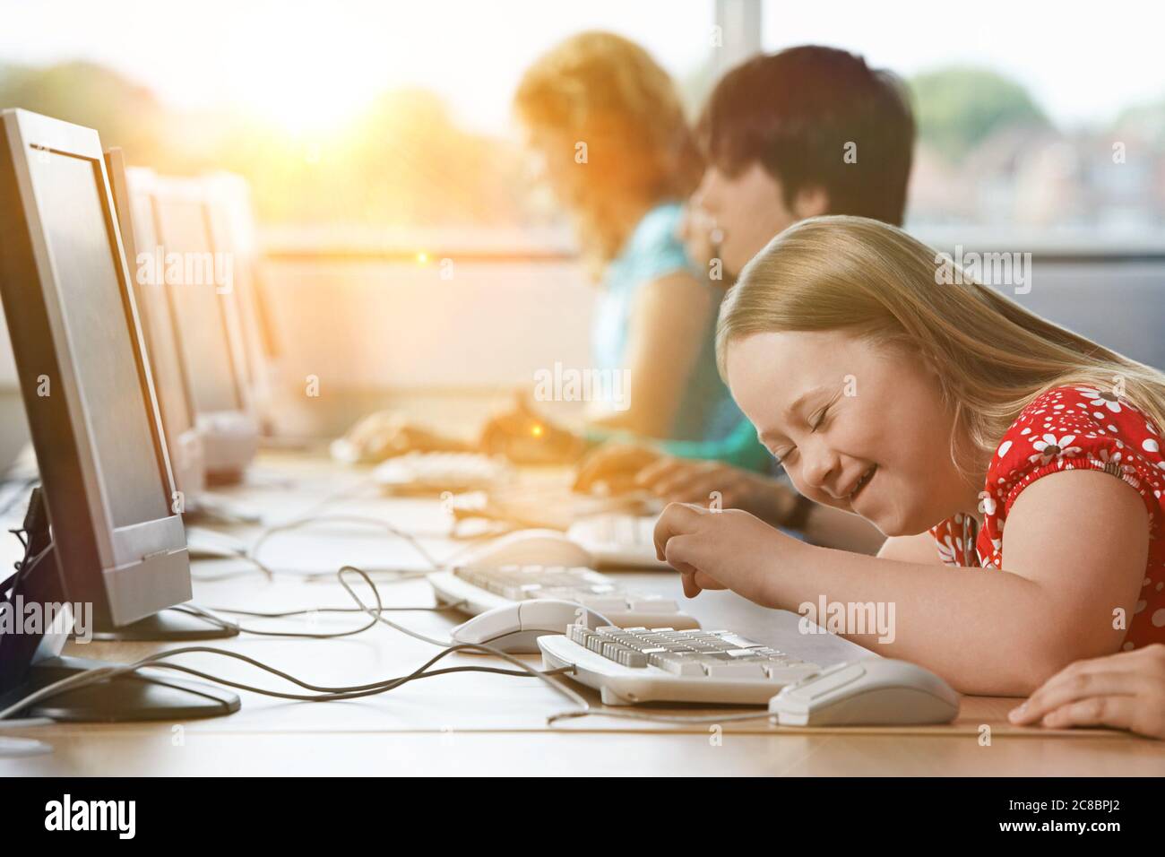 Girl with Down syndrome using computer at school Stock Photo - Alamy