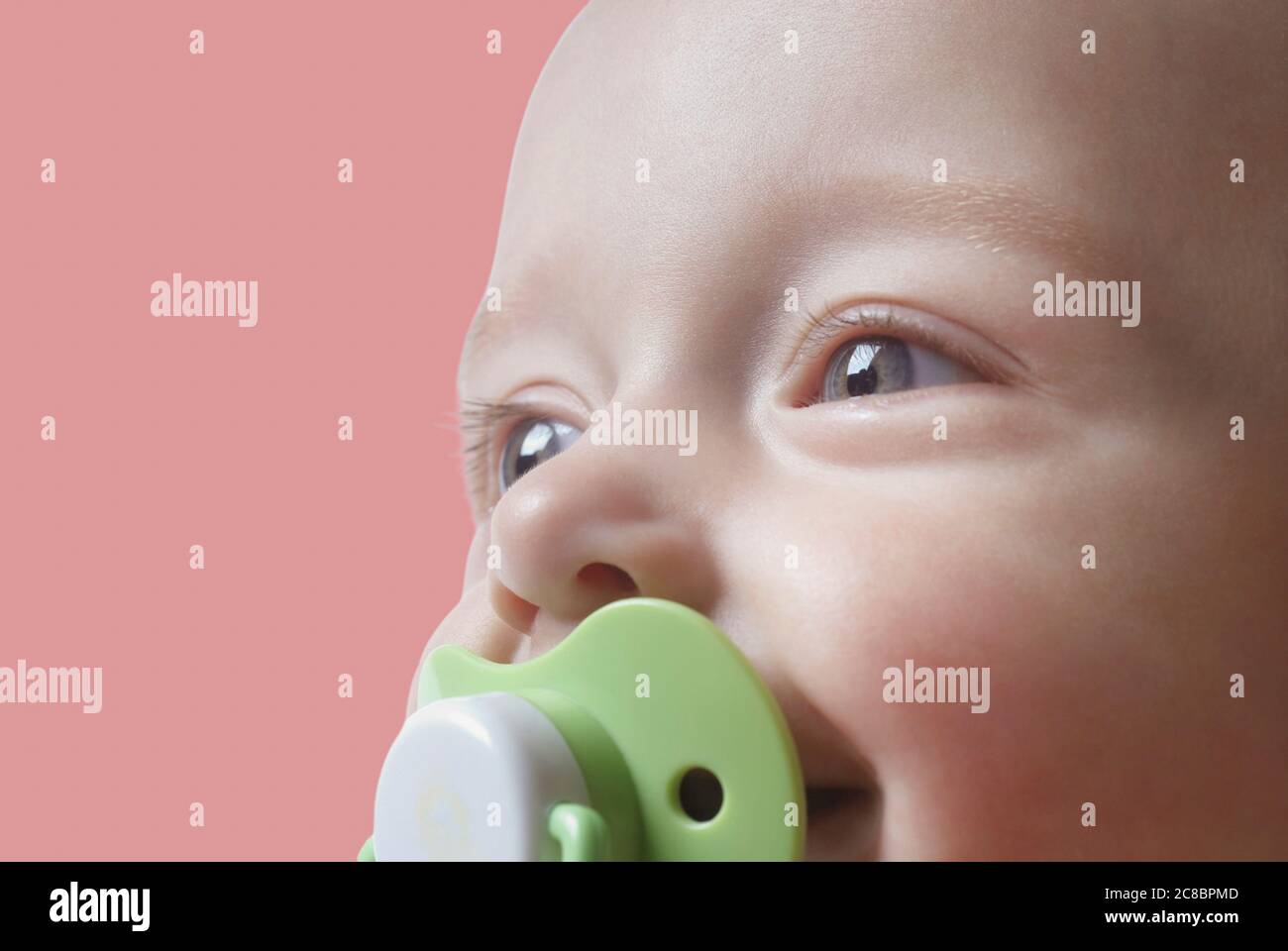 Baby girl with pacifier against pink background Stock Photo - Alamy