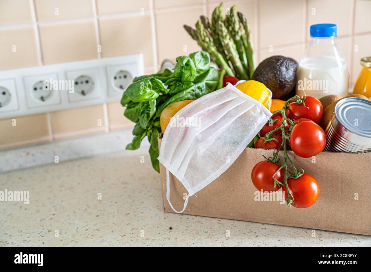 Safe food delivery concept - groceries in box with medical mask Stock ...