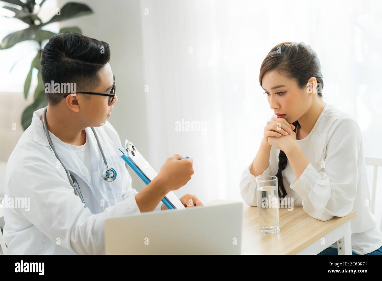 Portrait of female Obstetrician-gynecologist consulting woman in ...