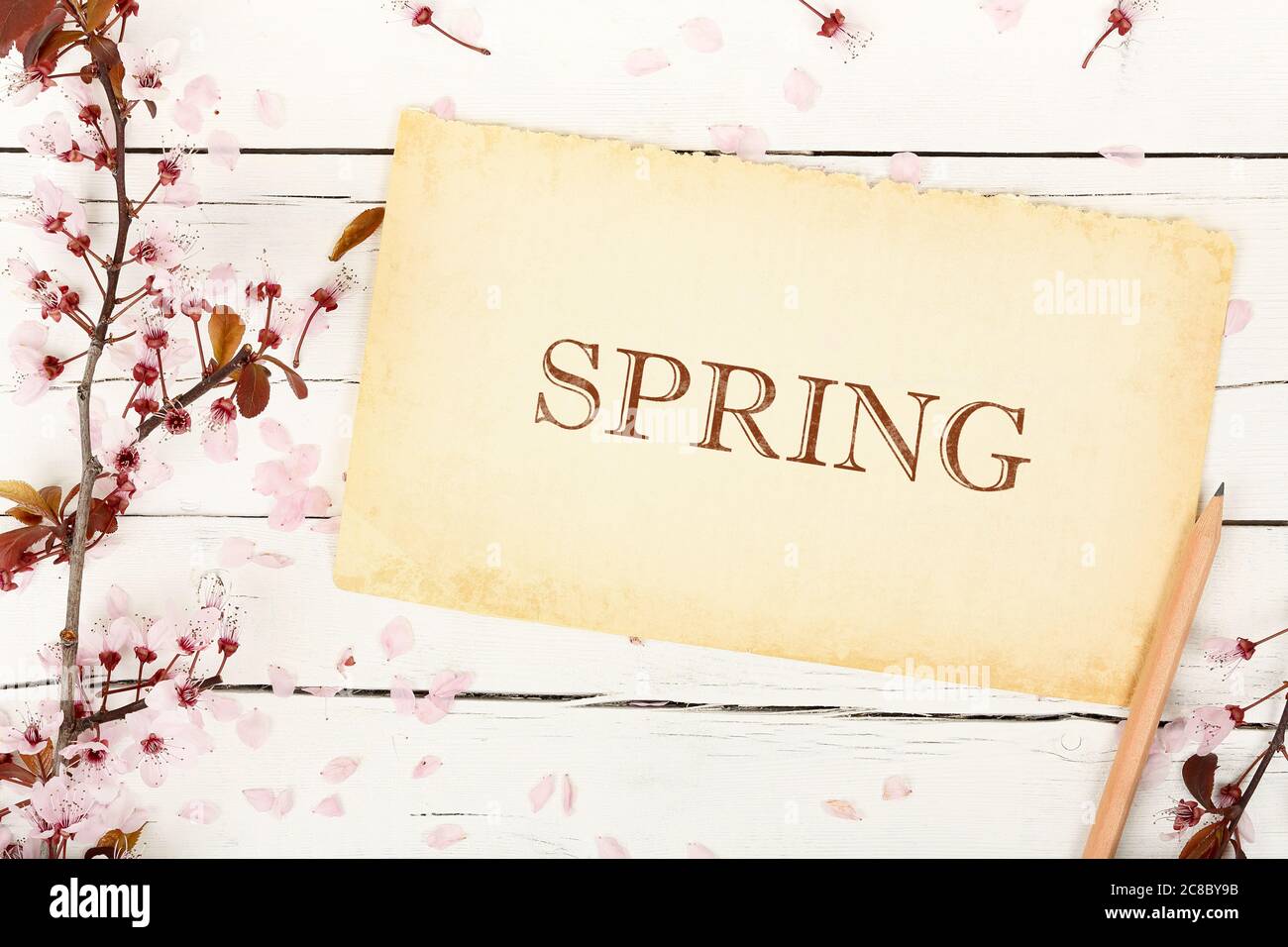 spring written on aged paper with almond tree twig on white wood Stock ...