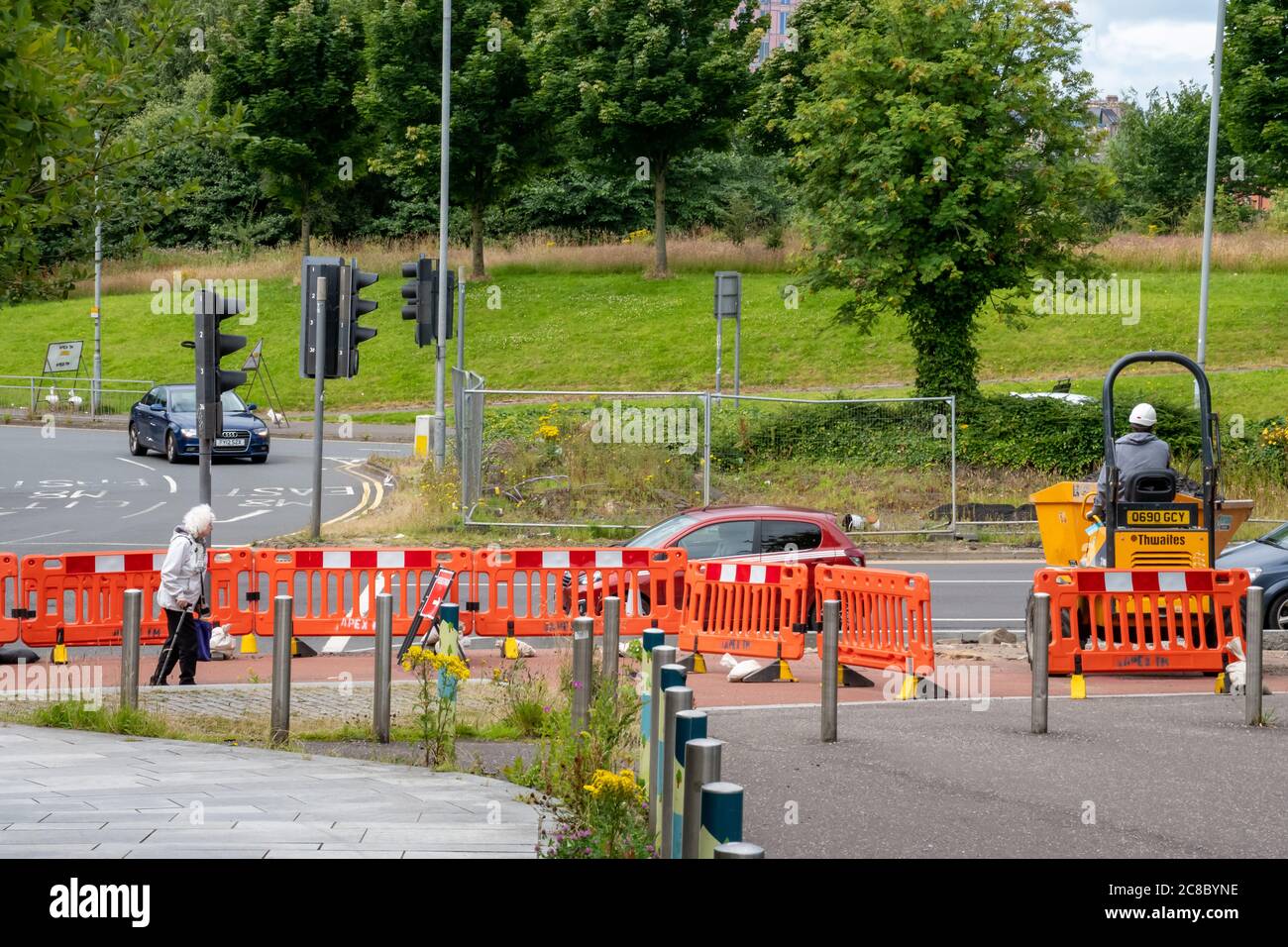 A construction worker driver a vehicle by the roadside as roadworks are ...