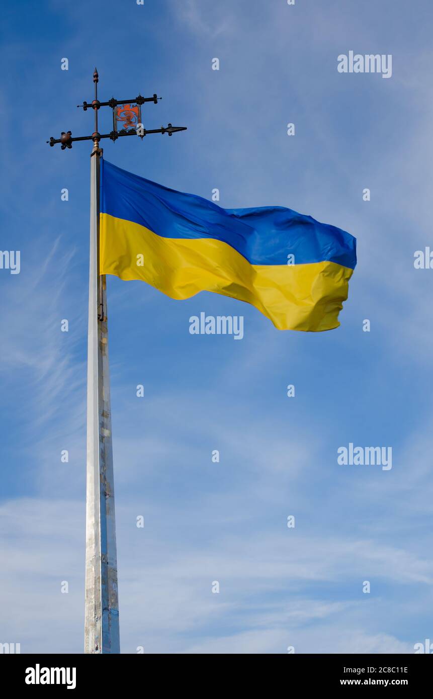 The blue-yellow Ukrainian flag with the emblem of Lviv on the flagpole ...