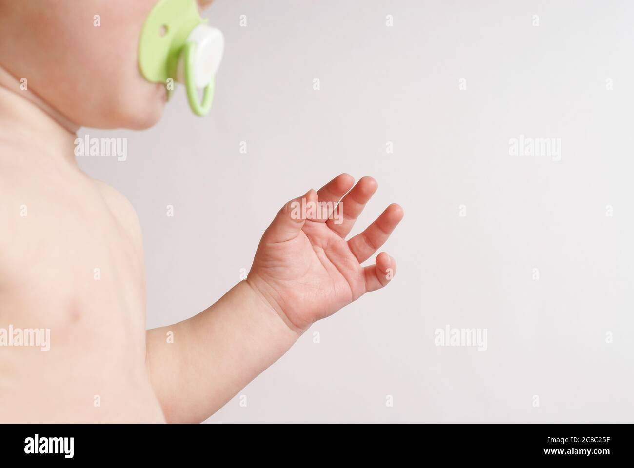 Baby with pacifier mid section Stock Photo - Alamy