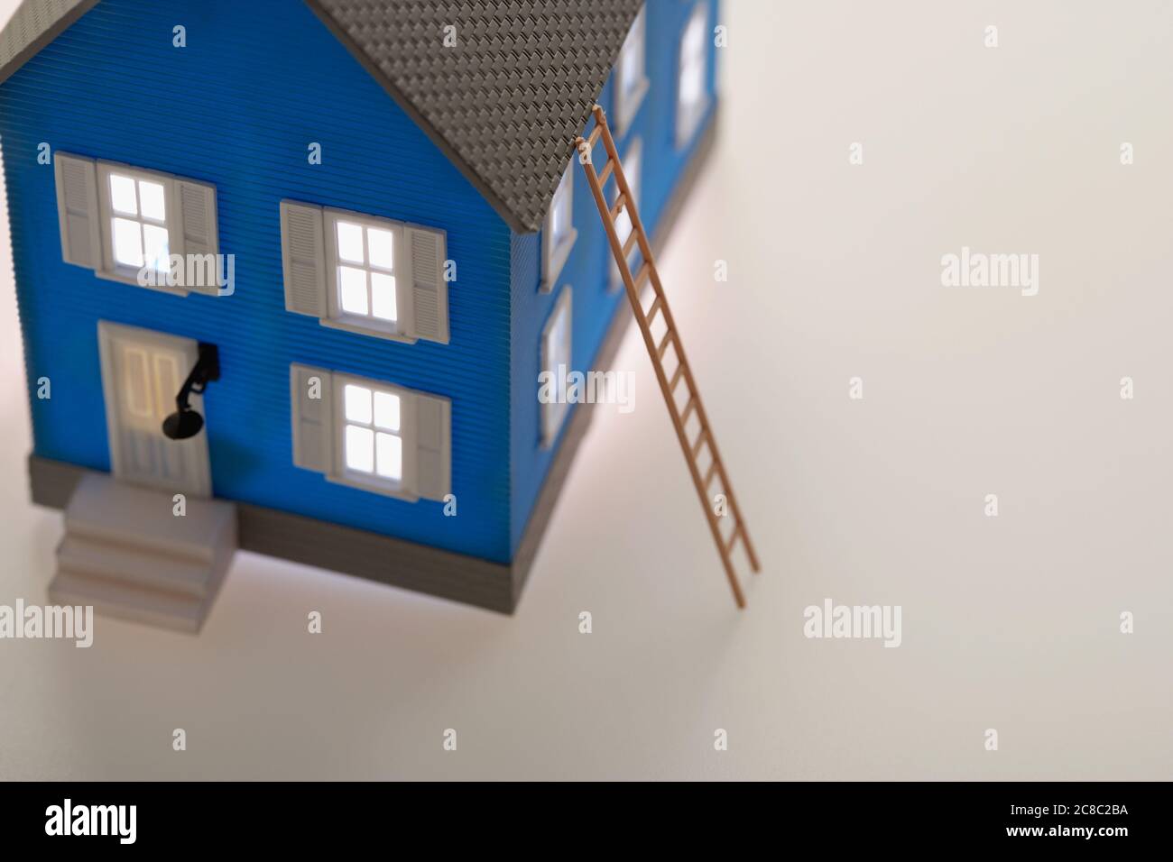 Illuminated little blue model house with ladder Stock Photo - Alamy