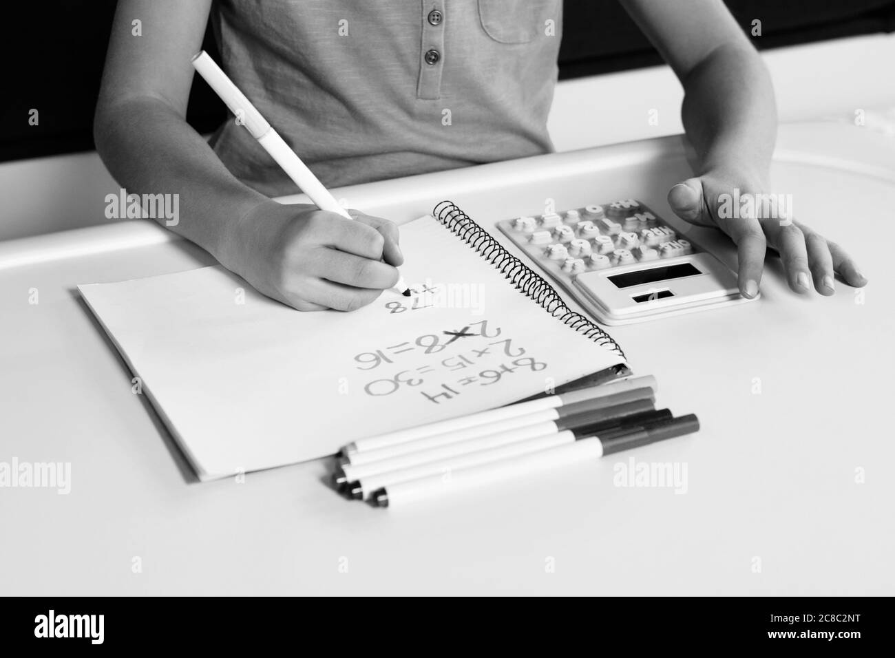 Black and white photo of Child doing maths homework using calculator ...