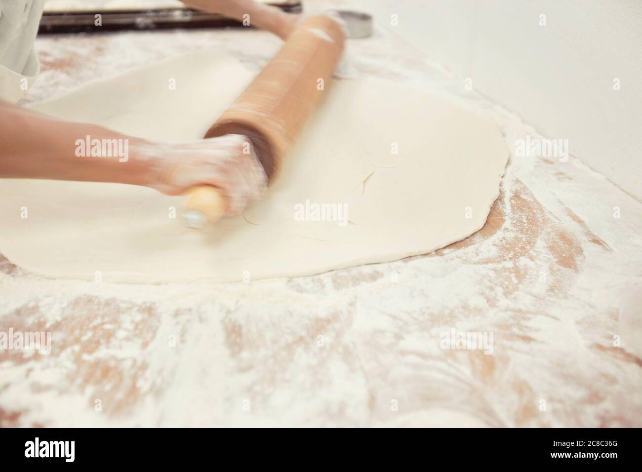 Baker's hands rolling bread in kitchen Stock Photo - Alamy
