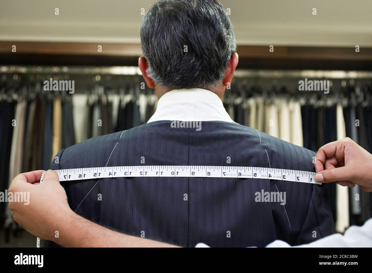 Tailor measuring business man for suit Stock Photo - Alamy