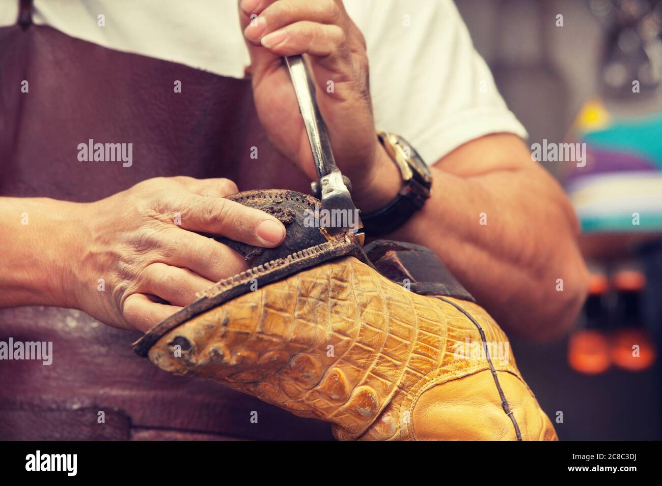 Cobbler craftsman fixing leather boot using tools Stock Photo - Alamy