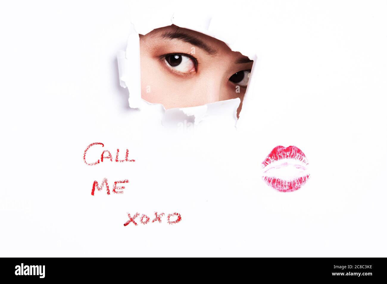 Asian woman pearing through ripped paper Stock Photo - Alamy