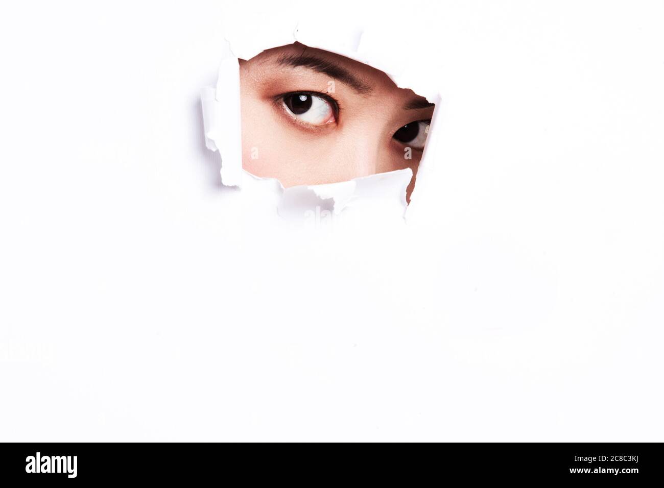 Asian woman pearing through ripped paper Stock Photo - Alamy