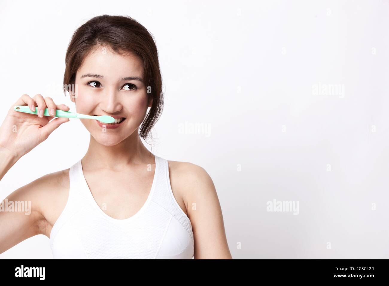 Pretty young woman brushing her teeth Stock Photo - Alamy