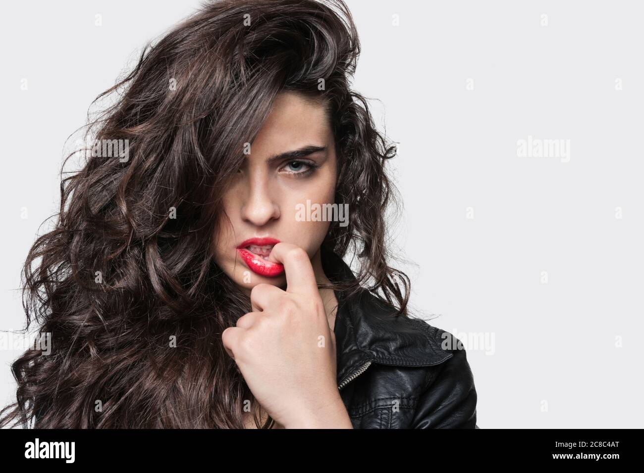 Attractive female biting finger on lips Stock Photo - Alamy