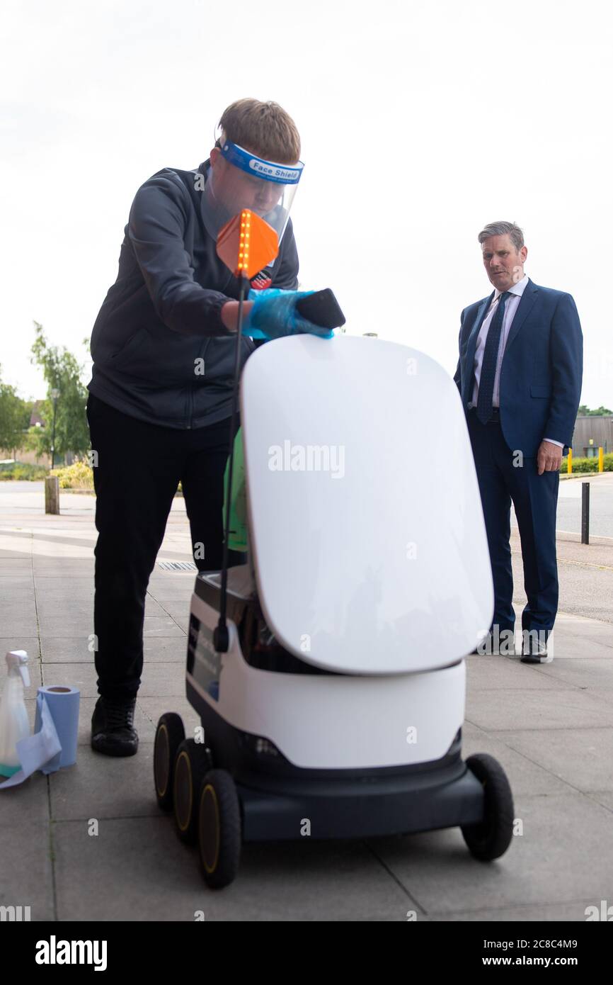 Labour Leader Keir Starmer looks on as a member of staff loads produce ...