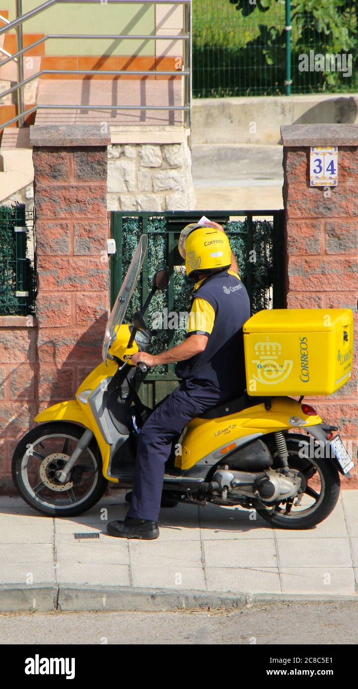 Postman from the Spanish post office Correos delivering post from a ...
