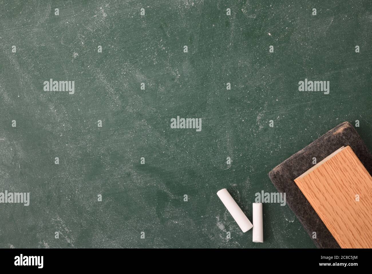 Erased and dirty class blackboard with white chalk and eraser close up ...