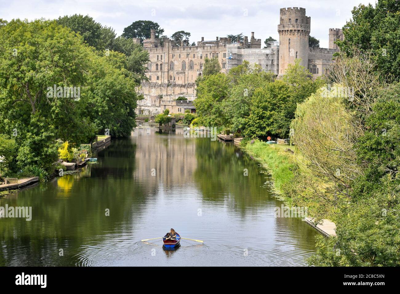People row along the River Avon and pass Warwick Castle, Warwickshire ...