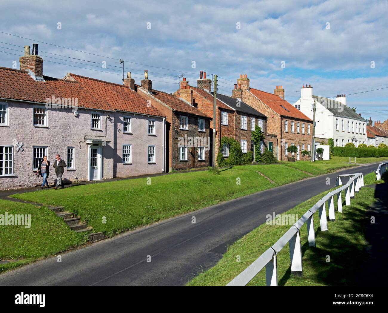 Couple walking dog in the village of Stillington, North Yorkshire ...