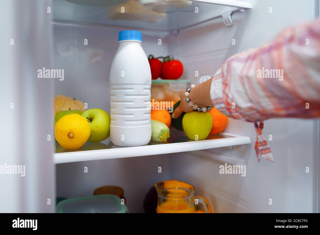 Hand of a woman taking food from the fridge Stock Photo - Alamy