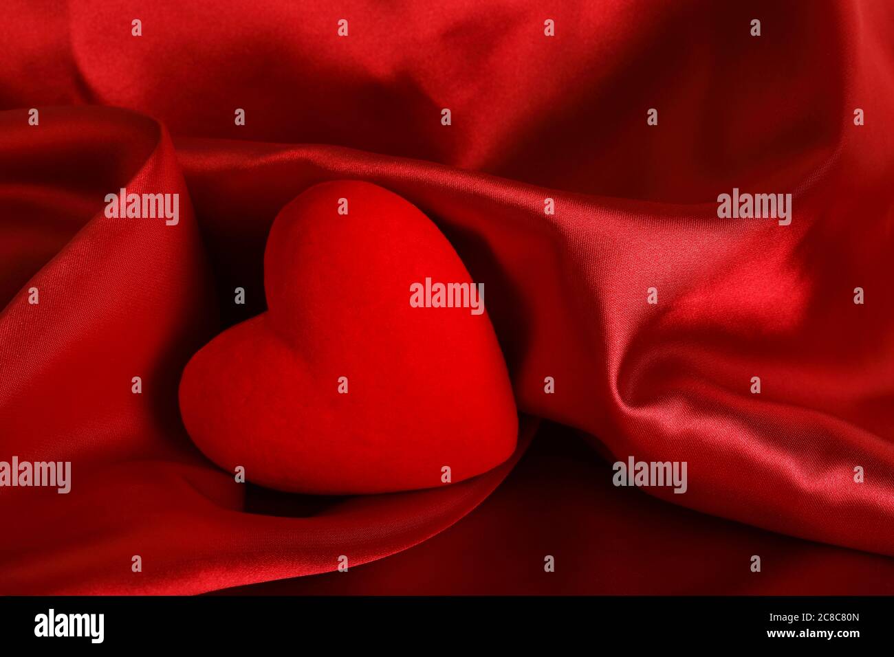 red heart on satin fabric Stock Photo - Alamy