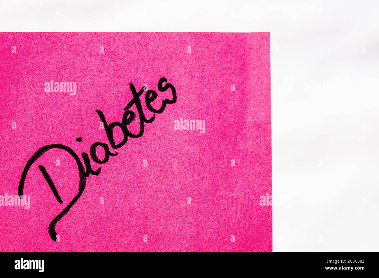 Diabetes handwriting text close up isolated on pink paper with copy ...