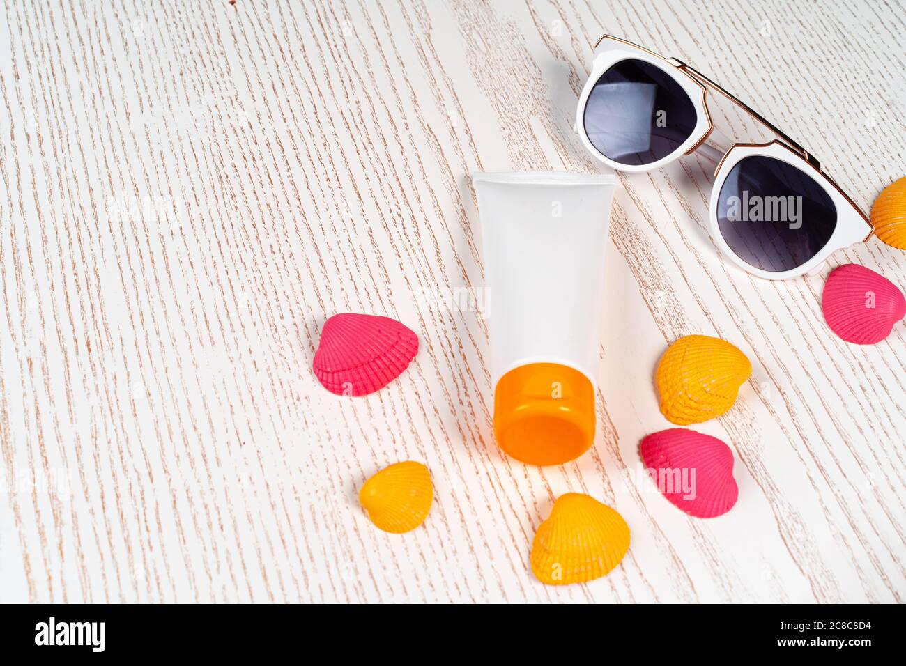 Sunblock lotion with colored seashells on wooden board Stock Photo - Alamy