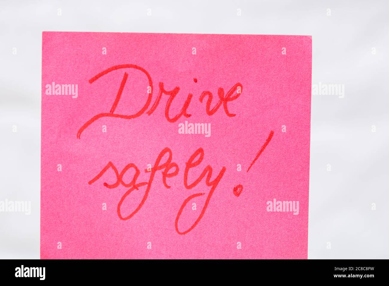 Drive safely handwriting text close up isolated on pink paper with copy ...