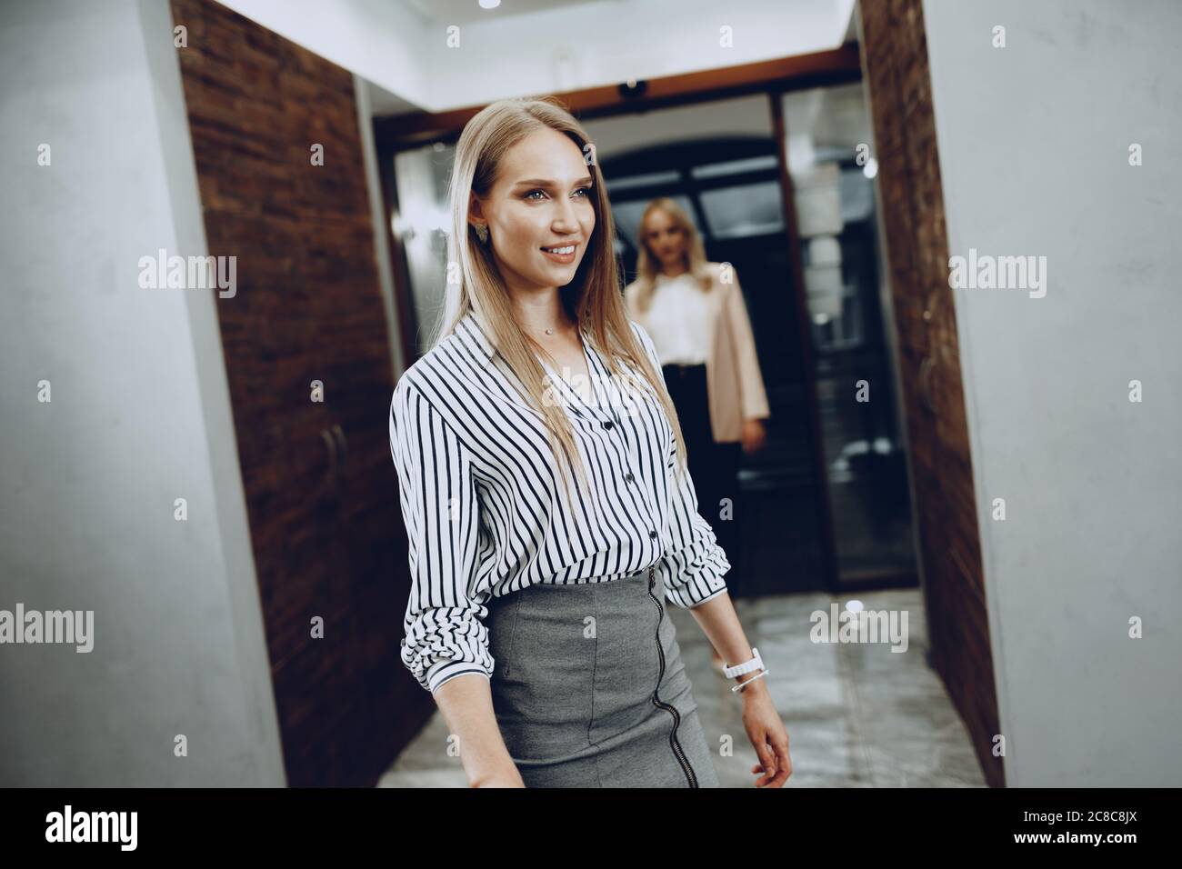 Two young women in formal clothes entering hotel lobby Stock Photo - Alamy