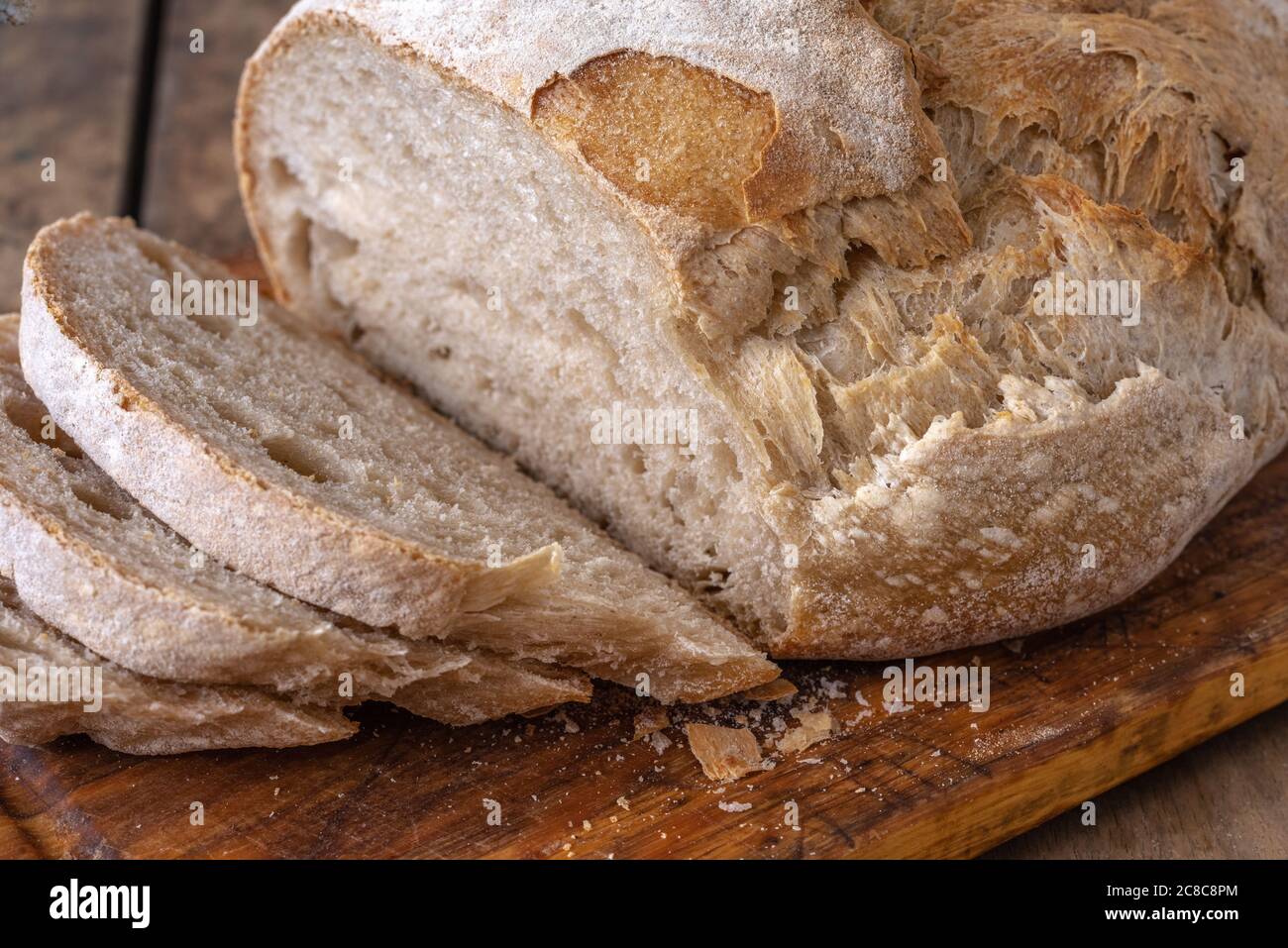 Sliced organic wheat bread and flour on a table Stock Photo - Alamy
