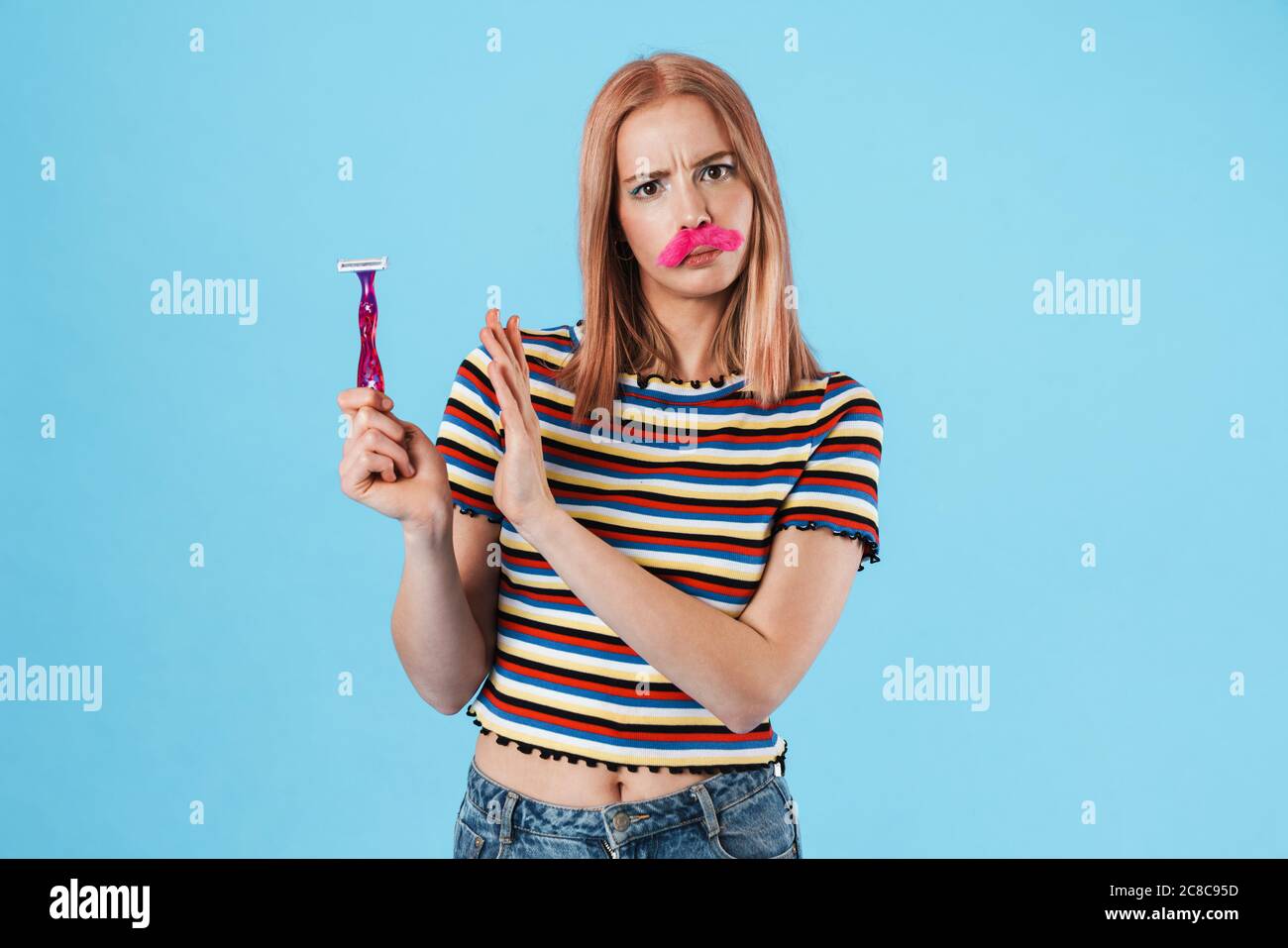 Image of confused woman with fake mustache holding razor and making ...