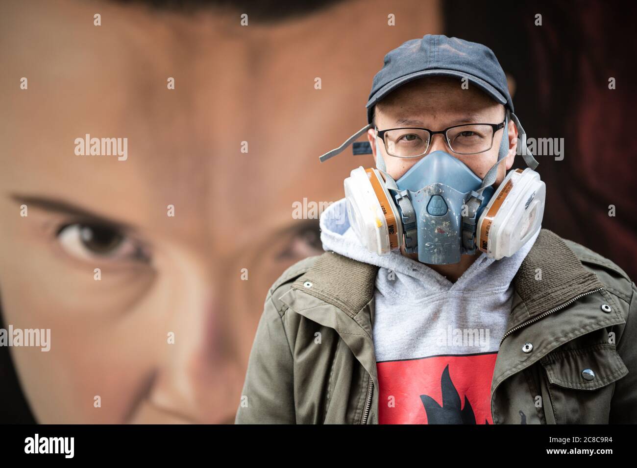 Portrait of Street artist, Akse P19, standing in front of his murals ...