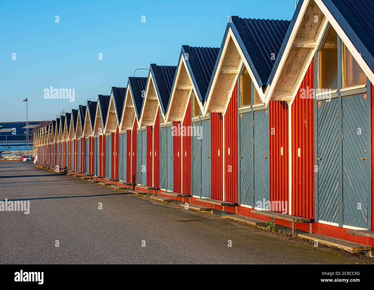Long row of small, red storage houses with blue doors Stock Photo - Alamy
