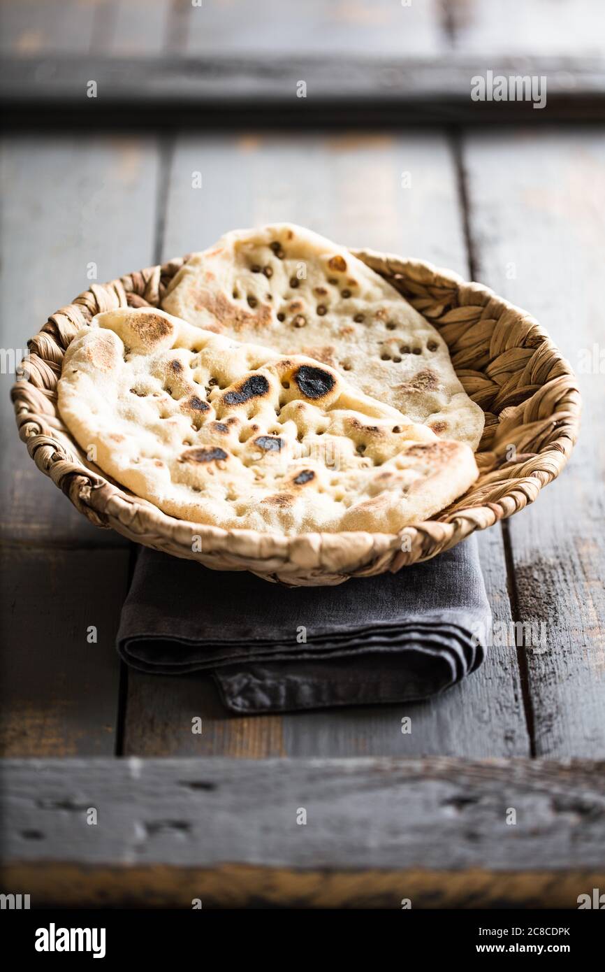 Vegan recipe flatbread. Charred flatbread served in a rustic basket on ...