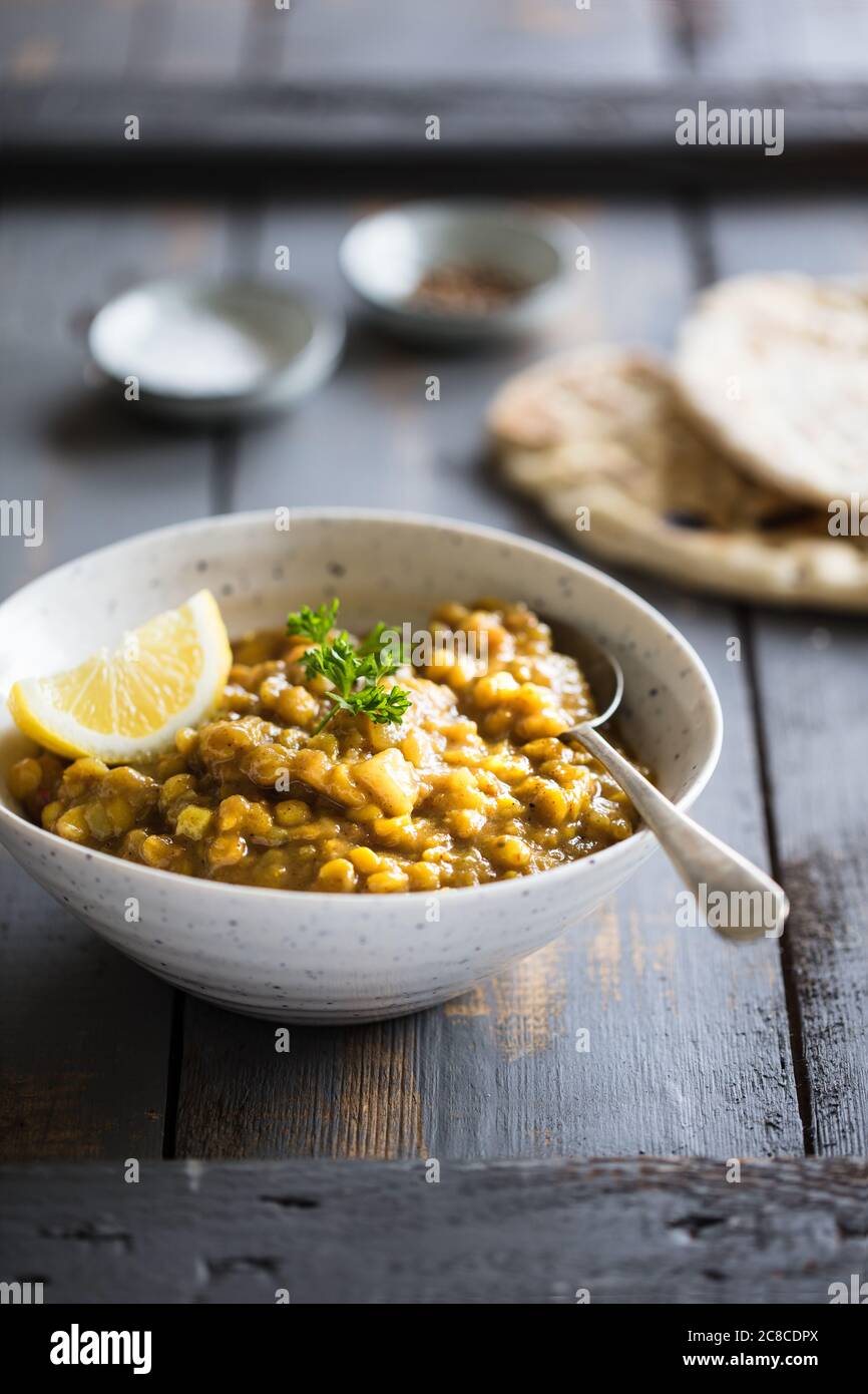 Lentil dal. Vegan friendly dhal served with lemon and herb garnish in a ...