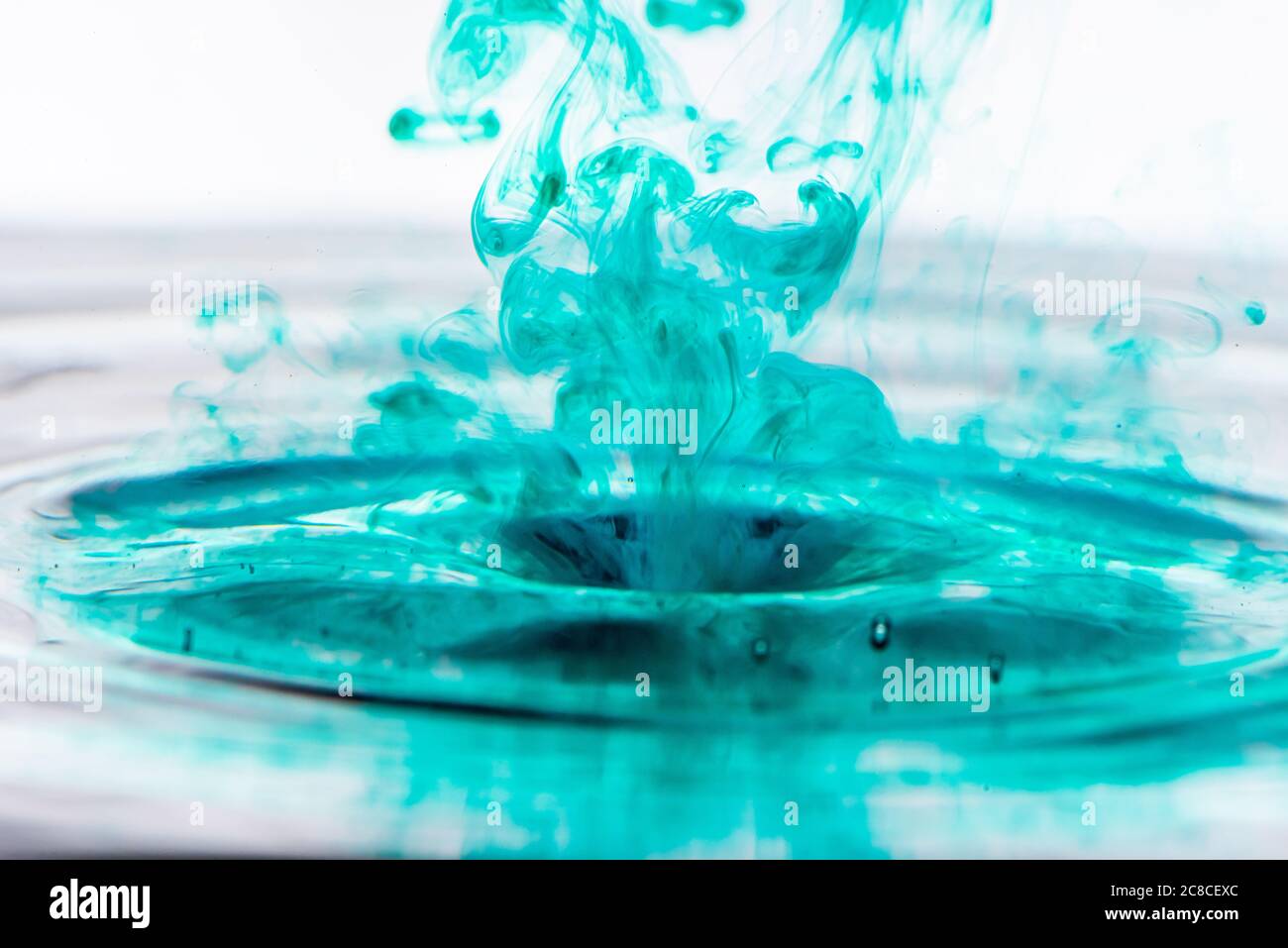 Green colored water drop splashing in clear water Stock Photo - Alamy