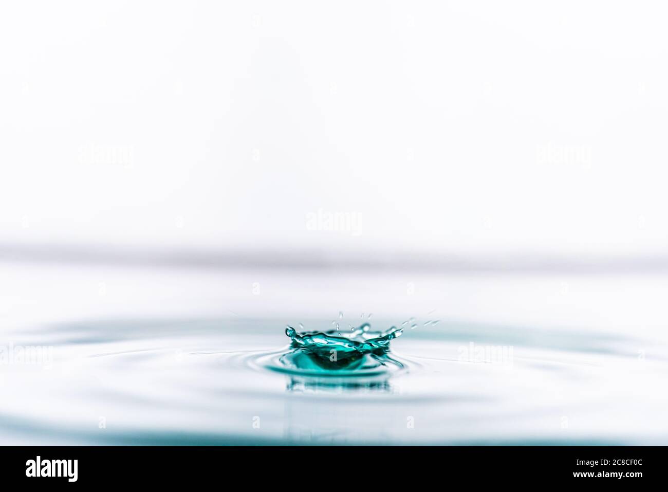 Green colored water drop splashing in clear water Stock Photo - Alamy
