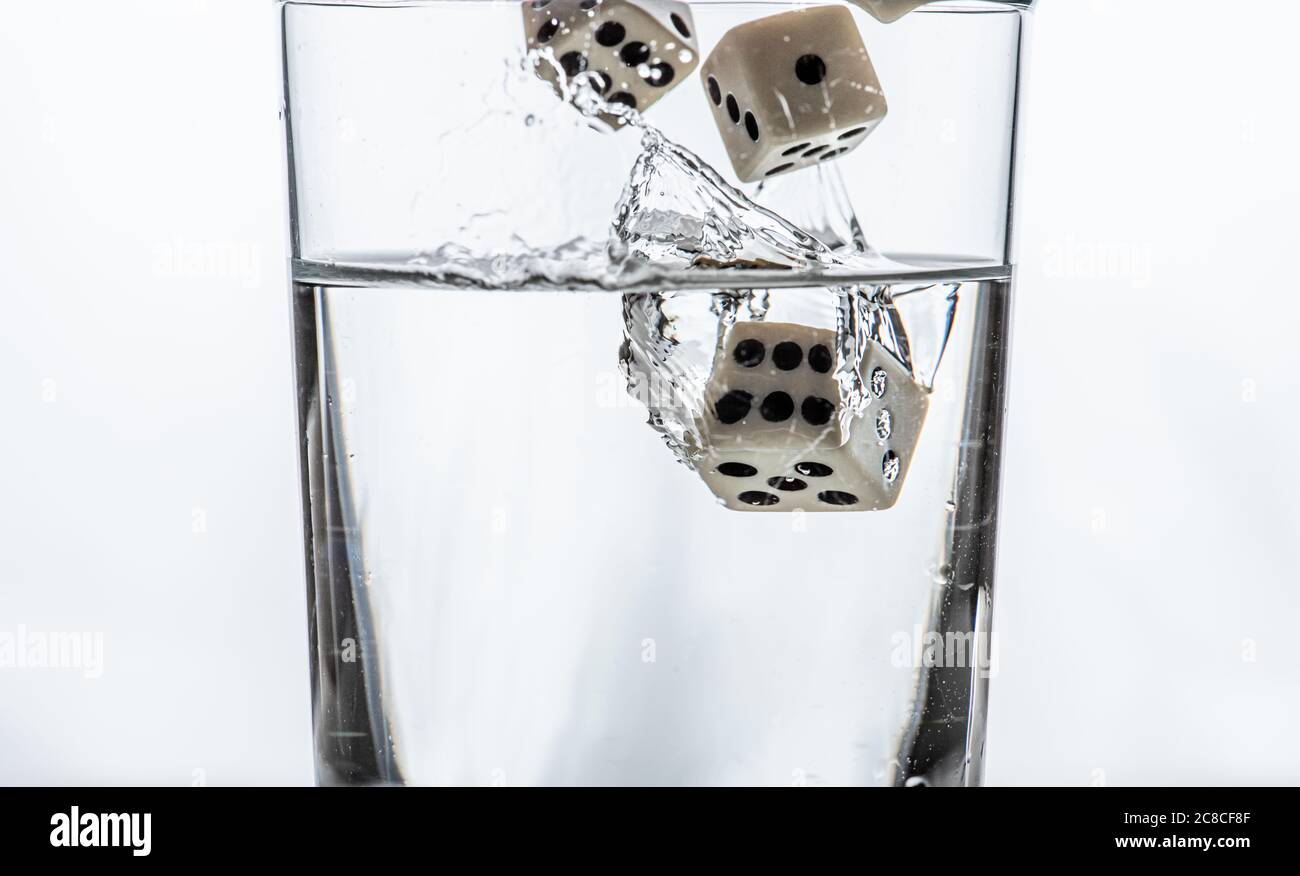 Dice splashing into a glass of water Stock Photo - Alamy