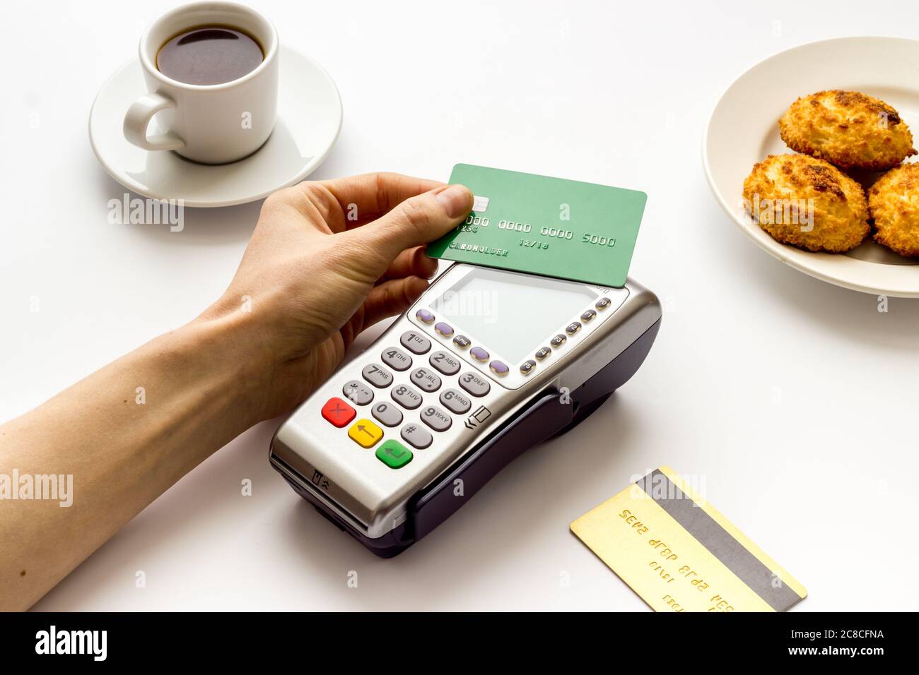 Payment by credit card. Hand hold card near terminal on white table ...