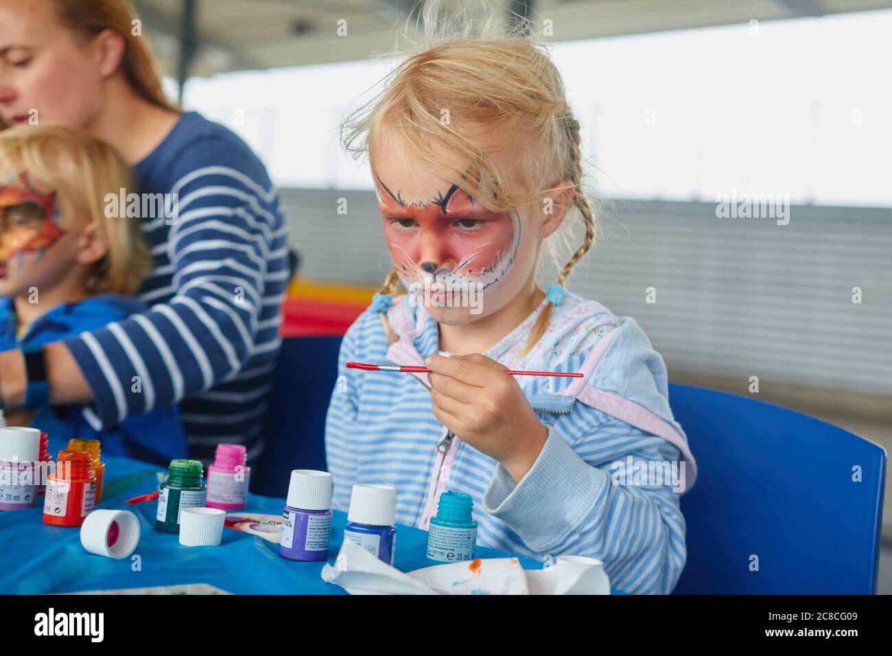 Face painting children at a family fun day. Face paint fun and many ...