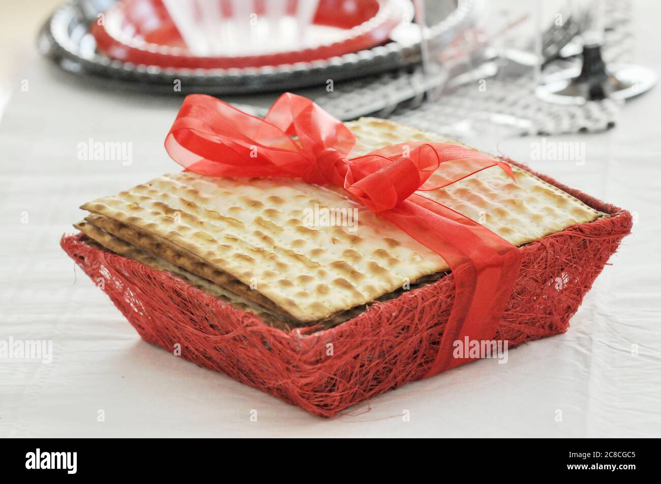 Matzo wrapped with a ribbon on a Jewish Passover table set with ...